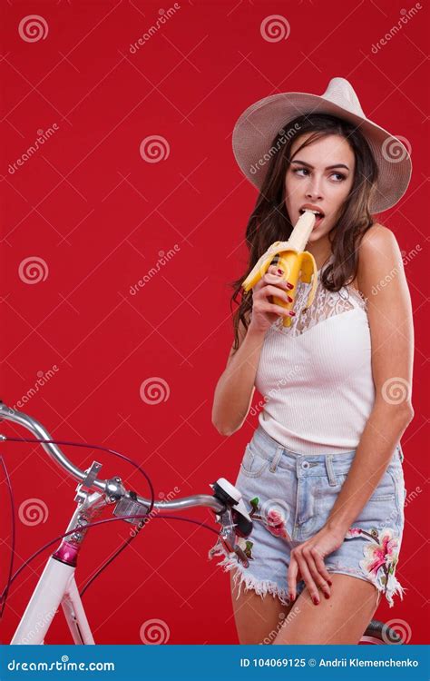 Girl Eating A Banana Next To A Bicycle On A Red Background Stock Image Image Of Caucasian