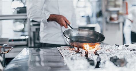 프라이팬에 불이 붙었습니다 부엌에서 음식을 요리하는 흰색 유니폼을 입은 요리사 직장에서 바쁜 하루 사진 Unsplash의 우크라이나 이미지