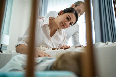 백인 부모는 집에서 침실에서 잠자는 아기 소년을 돌봅니다 매력적인 행복한 가족 아름다운 배려 어머니는 아침에 침대에 작은 아이 유아 를 잠자는 안락한 잠에 담요를 두고