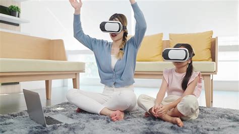 아시아의 어머니와 딸은 기술 가상 현실 헤드셋의 안경을 쓰고 거실의 바닥에 앉아 Labtop에서 게임을 하고 있다 2명에 대한 스톡 사진 및 기타 이미지 Istock