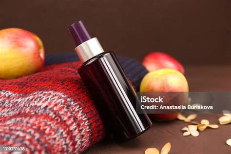 브랜드가 없는 다크 브라운 스프레이 보틀 레드 니트 스웨터 사과 갈색 배경의 드라이 수국꽃 화장품 포장 모형 템플릿 전면 보기 천연 유기농 스파 바디 미스트 0명에 대한