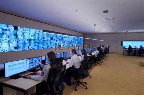 在闭路电视监控室工作的一组安全数据中心操作员查看多个监视器高清摄影大图 千库网