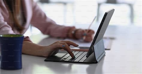 태블릿 컴퓨터의 키보드에 타이핑하고 사무실 책상에서 메모를 쓰는 사업가를 닫습니다 사진 Unsplash의 태국 이미지