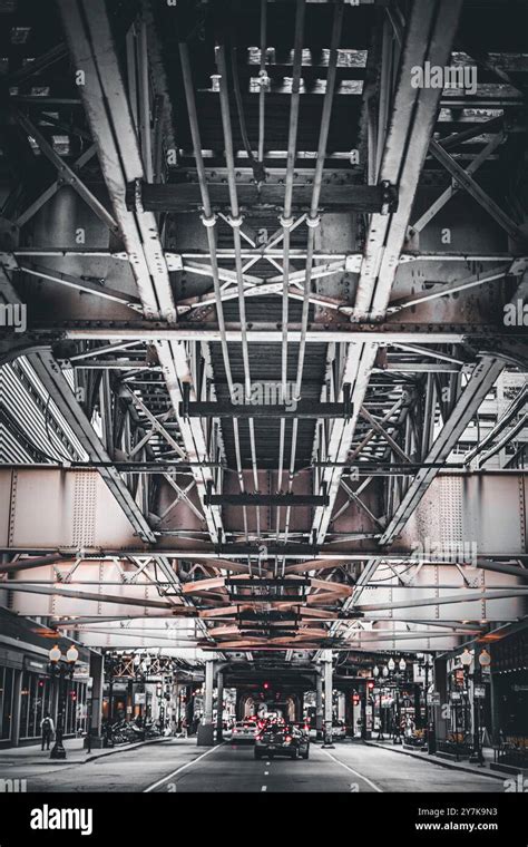 Underside View Of Elevated Train Track With City Traffic Below