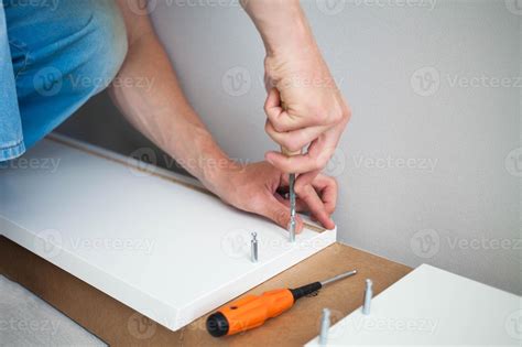 Close Up Of Man Hand Furniture Assembler Make Flat Pack White