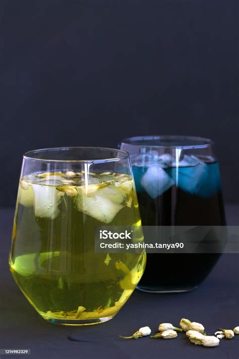 아이스 버터플라이 완두콩 차와 재스민 차 검은 탁자 위에 마른 꽃이 있는 차가운 차 두 잔 건강한 라이프 스타일 검은 배경에