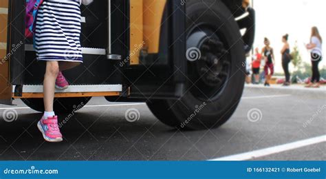 A Female Student Steps Off A School Bus Stock Image Image Of Bookbag