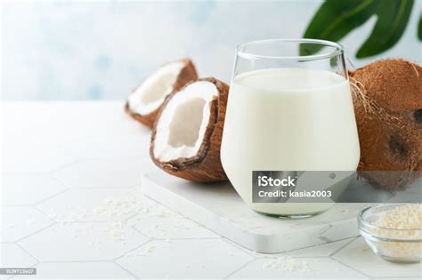 코코넛 밀크와 코코넛 한 잔이 흰색 배경에 텍스트를 위한 공간이 있습니다 코코넛 비건 우유 비 유제품 또는 유제품 무료 우유 개념 건강한 비건 음식 0명에 대한 스톡 사진