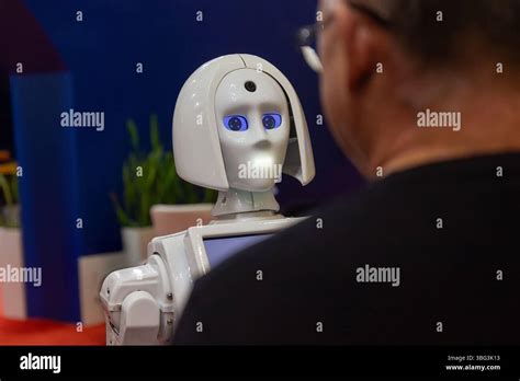 A Man Communicates From A Humanoid Robot Assistant Technology Stock