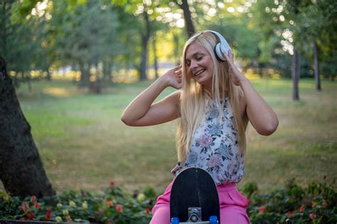 금발의 젊은 여성은 스케이트 보드와 산 근처 의 작은 도시에서 거리를 걷고 뒤에서 보았다 청소년과 행복 라이프 스타일 개념 거리에 대한 스톡 사진 및 기타 이미지 Istock