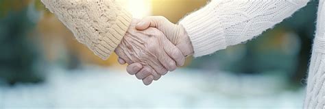 A Young Hand Holding An Elderly Persons Symbolizing Care And Support