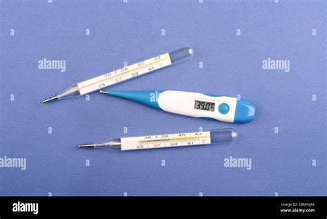 A Glass Mercury Thermometer And An Electronic Thermometer Indicate Heat Three Body Thermometers