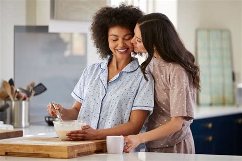 Loving Same Sex Female Couple Wearing Pyjamas Making Morning Pancakes