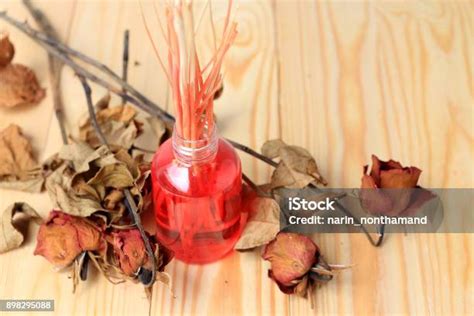 향수 기관총 설정의 손 아로마 막대기로 병 및 레드 장미 소나무 나무 벽 배경 테이블에 향수 스프레이 병을 건조 Fragrance Launch에 대한 스톡 사진 및 기타