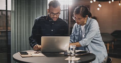 사무실 테이블에 둘러앉아 회의를 하는 동안 노트북으로 함께 작업하는 두 명의 다양한 젊은 사업가 사진 Unsplash의 컴퓨터 이미지