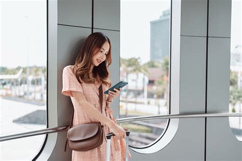 아시아 여자 십 대 휴가 여름 편안한 여행을 위해 수하물 가방 및 배낭 공항 터미널 휴식에서 스마트폰을 사용 하 여 대기 비행