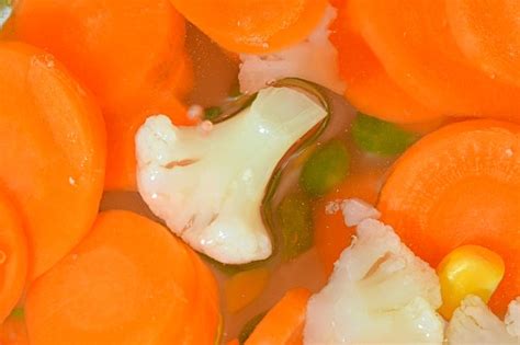 물 배경에 당근 완두콩 콜리플라워 옥수수가 있는 야채의 클로즈업 보기 끓는 수프 야채의 질감입니다 평면 디자인 평면도 가로 매크로 이미지입니다 초점 흐림 0명에 대한 스톡