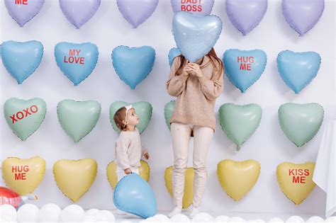 아름다운 젊은 어머니와 작은 귀여운 딸이 함께 재미 함께 다채로운 심장 풍선 배경에 서서 파란색 발렌타인 데이 풍선을 들고 생일 벨렌틴 어머니의 날 2 3 살에 대한 스톡
