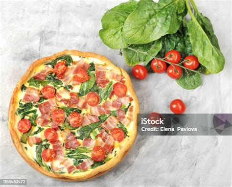 클래식 프렌치 파이 키쉬 크림 치킨 계란 시금치 베이컨으로 가득 프레임에 녹색 시금치와 체리 토마토의 무리 위에서 볼 수 있습니다 갈레트에 대한 스톡 사진 및 기타 이미지