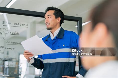 파란색 작업 재킷을 입은 전문직 남성이 현대적인 사무실 환경에서 Esg 다이어그램을 제시하며 팀워크와 협업을 보여줍니다 그의