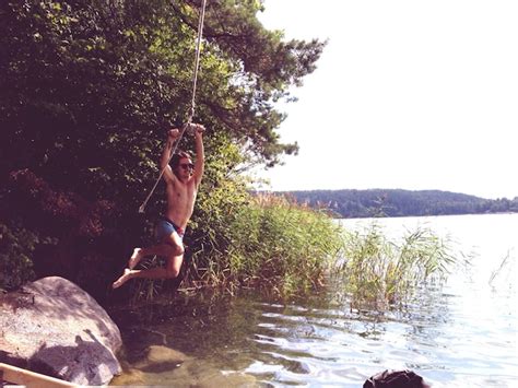 Premium Photo Young Man Enjoying Rope Swing Over Lake Against Clear Sky