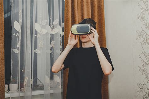 Vr 헬멧을 쓰고 있는 청년이 집 내부의 가상 현실에서 물체와 상호 작용합니다 20 24세에 대한 스톡 사진 및 기타 이미지 20 24세 3차원 형태 가상현실