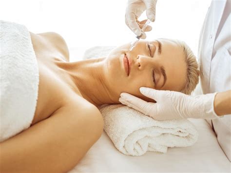 미용사 의사는 주사기로 여성의 얼굴에 미용 절차를 수행합니다 미용 의학 및 수술 미용 주사 개념 프리미엄 사진