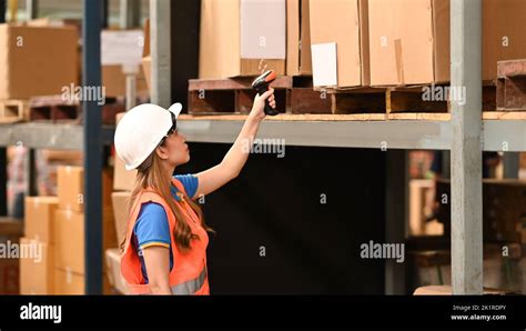 Female Warehouse Worker With Barcode Scanner Checking Inventory Boxes On Shelf In A Warehouse