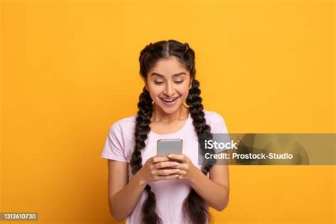 노란 배경에 고립 된 스마트 폰을 사용하여 미소 인도 여자 광고에 대한 스톡 사진 및 기타 이미지 광고 말하기 메시지 Istock