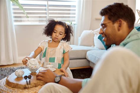 사랑 아버지와 소녀는 놀고 미소 짓고 기쁨으로 쾌활하고 유대감과 양질의 시간을 보냅니다 가족 남자 부모와 딸이 차를 마시고 함께 장난스럽고 사랑스럽고 거실과 휴식 시간의