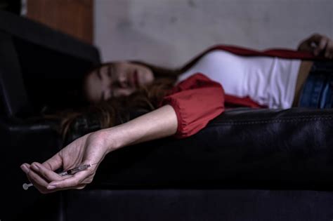 Drugged Woman Lying With A Syringe Drug Overdose And The Shocked