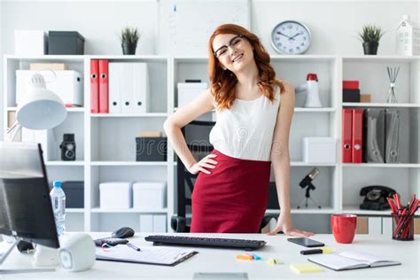 Beautiful Young Girl Stands In The Office Near The Table The Girl Put One Hand On Her Hip And