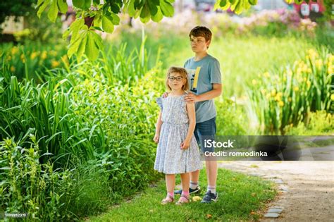 학교 소년과 여동생 미취학 아동이 공원에서 함께 놀고 있다 행복한 두 아이가 놀고 화창한 여름날을 즐겁게 보내고 있습니다 사랑에 빠진 형제 자매 사랑스러운 여동생과 남동생