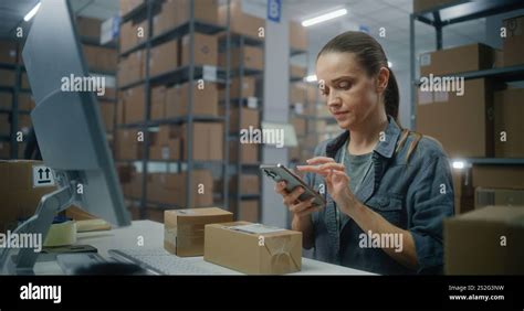 Female Logistics Specialist Scans Parcels Using Smartphone Prepares Packages For Shipping