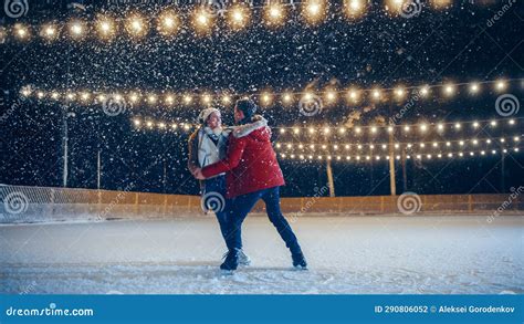 Romantic Winter Snowy Evening Ice Skating Couple Having Fun On Ice