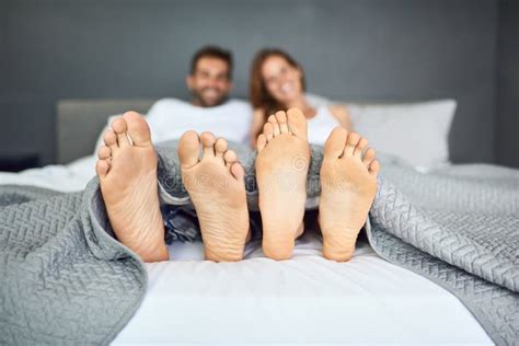 Sunday Is Bed Day A Happy Young Couple Relaxing In Bed With Their Feet