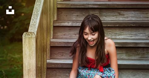 파란색과 흰색 꽃 드레스를 입은 여자가 갈색 나무 계단에 앉아 있다 사진 Unsplash의 무료 러시아 이미지