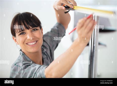Brunette Woman Measuring Window Sill Stock Photo Alamy