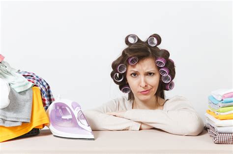 가벼운 옷 철와 다림 질 보드에 가족 의류를 다림 질에 머리에 컬러와 유부 하 녀 고민된 녀 흰색 배경에 고립 된 여자입니다 가사 개념입니다 광고에 대 한 공간을 복사