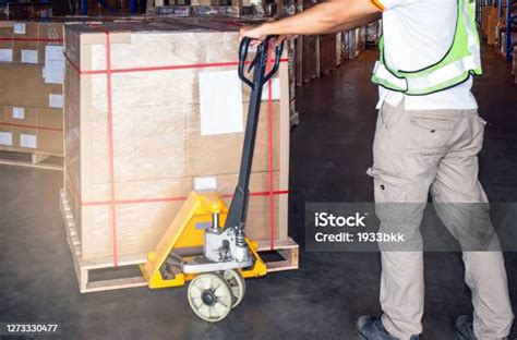 화물 선적 배달 화물 트럭 운송 팔레트에 큰 상자를 적재하는 손 팔레트 트럭으로 일하는 창고 작업자 공장 산업 건물에 대한 스톡