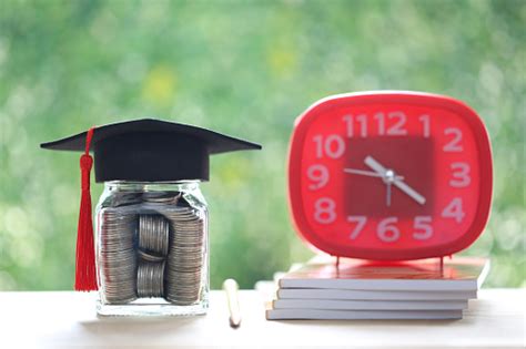 자연 녹색 배경에 유리 병과 알람 시계에 졸업 모자 교육 개념에 대한 돈을 절약 0명에 대한 스톡 사진 및 기타 이미지 0명