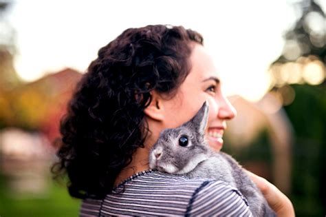 토끼 토끼를 들고 있는 동안 미소 짓는 귀여운 히스패닉 여성 가축에 대한 스톡 사진 및 기타 이미지 가축 곱슬 머리 미국 Istock