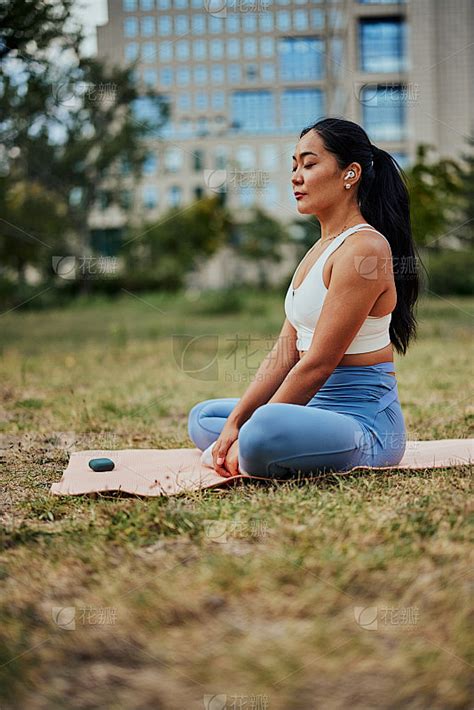 年轻的亚洲妇女在公园户外练习瑜伽