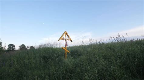 Symbol Of Faith In God In Field With Tall Grass Stands A Christian