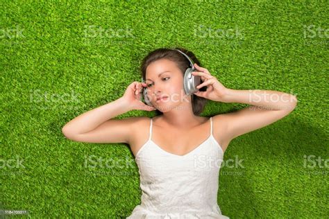 흰색 드레스와 헤드폰을 입은 아름다운 젊은 여성이 잔디 위에 누워 음악을 듣습니다 여름 컨셉 위에서 보기 건강한 생활방식에 대한 스톡 사진 및 기타 이미지 Istock