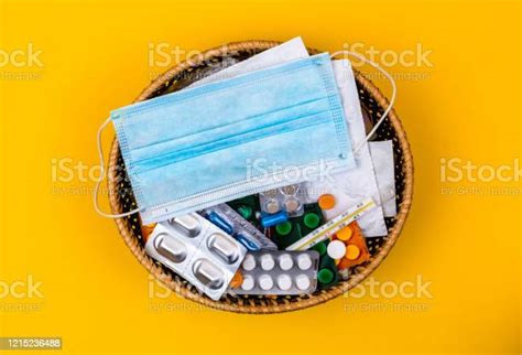 노란색 배경에 고리버들 바구니 바구니에 미친 마스크 공간을 복사합니다 텍스트 및 디자인을 위한 배치입니다 맨 위 보기 플랫 레이아웃 알 약과 비타민 0명에 대한 스톡 사진