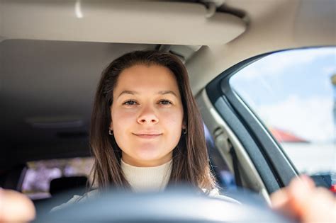 차를 운전하고 웃고 있는 행복한 여자 귀여운 젊은 성공 행복한 갈색 머리 여자가 차를 운전하고 있다 행복한 여성 운전자의 초상화 운전하기에 대한 스톡 사진 및 기타 이미지