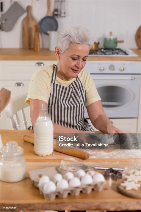 부엌에서 요리하는 행복한 노인 여자 세련 된 오래 된 성인 회색 머리 숙녀 할머니 반죽 반죽 굽기 쿠키 늙은 할머니는 집에서 만든 음식을 요리합니다 가정 주부 가사 개념