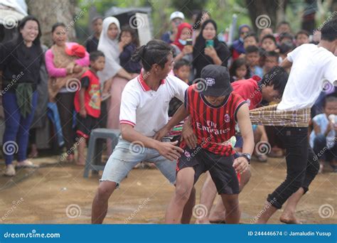 A Group Of Indonesians Tied Using Sarongs Pull Each Other In A