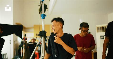 큰 파란색 테이블이 있는 방에서 사람 앞에서 마이크를 들고 있는 사람과 사진 Unsplash의 무료 사람의 이미지